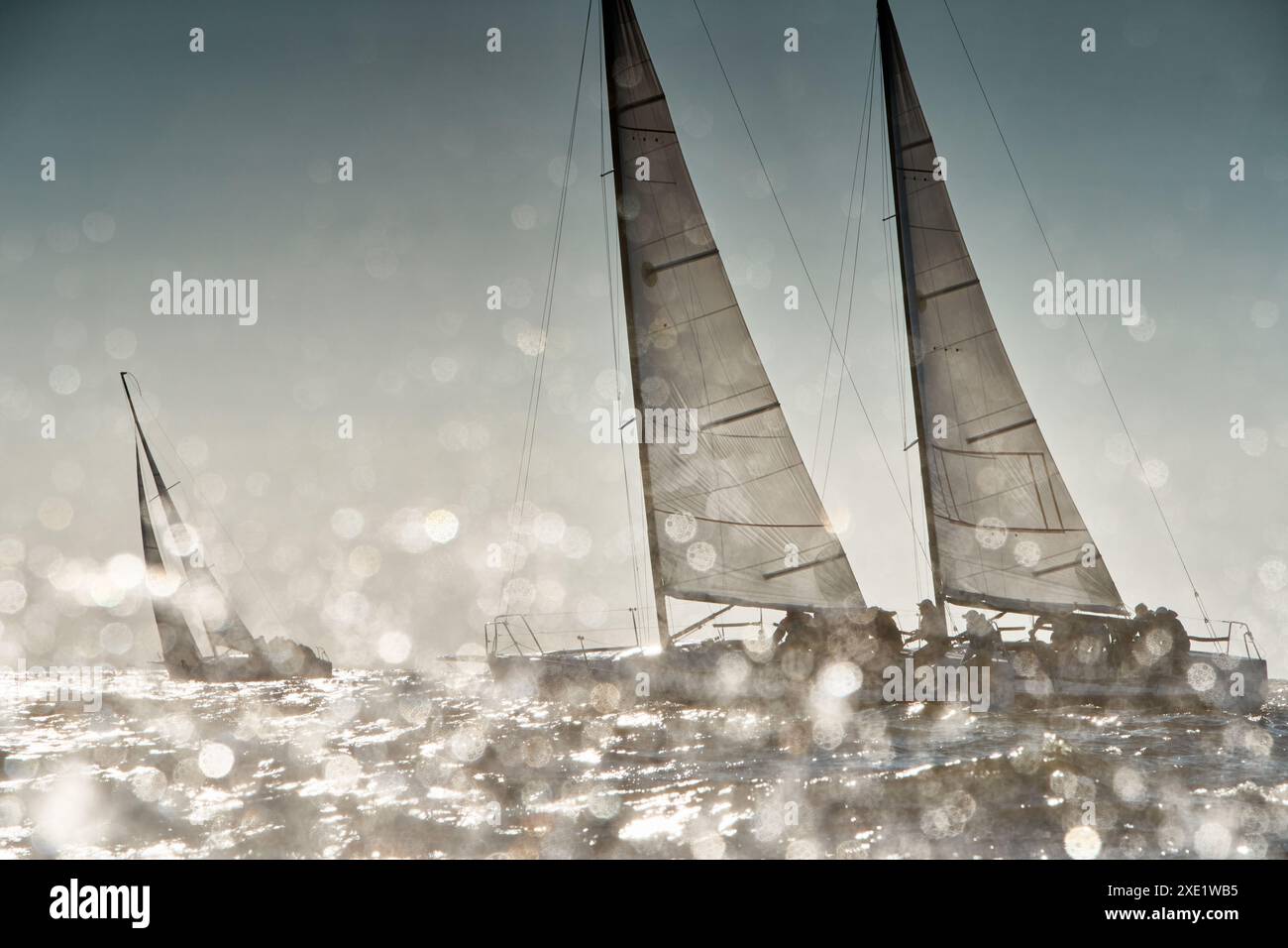 The view through the spray of how few sailboats are heeling at sunset ...