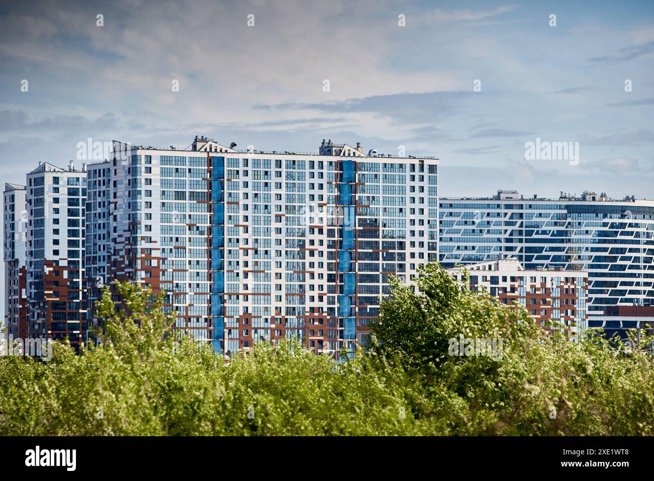 Huge colorful residential complex in sunny weather, green vegetation in ...