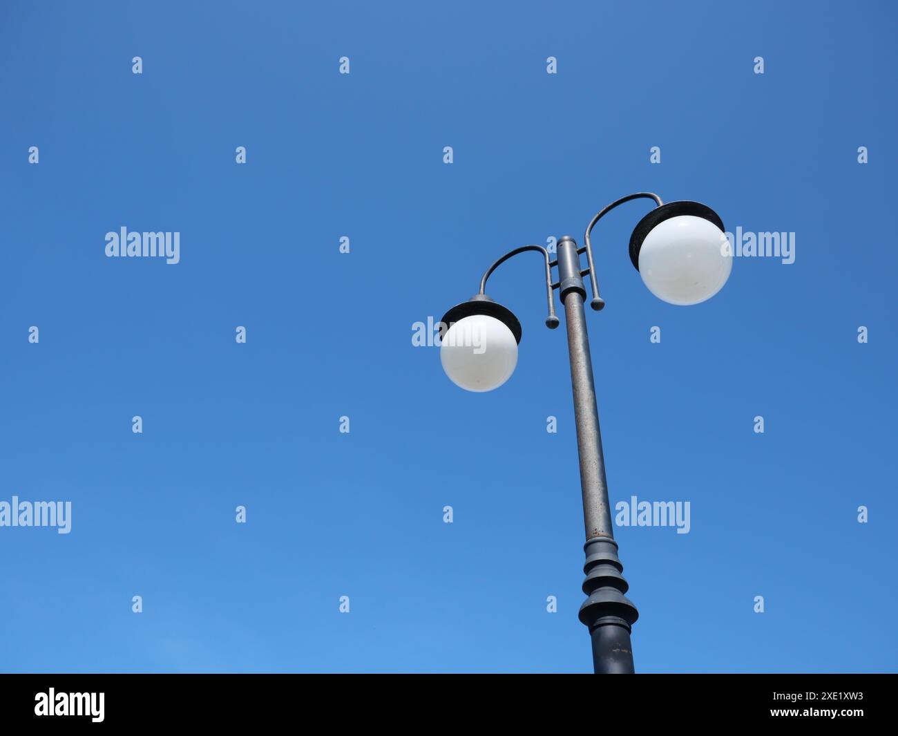 Lamp pole with round light bulbs on a blue sky background Stock Photo ...