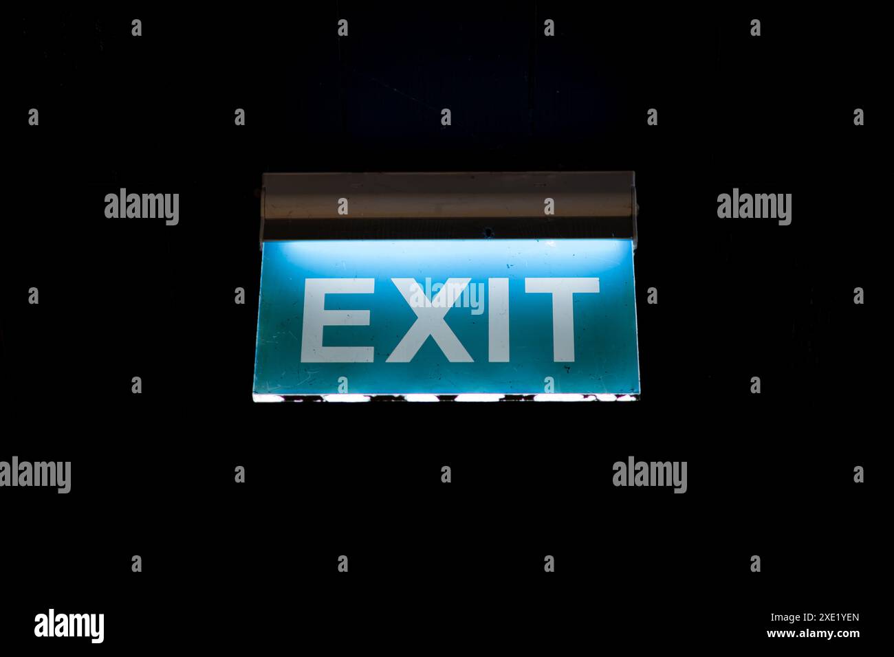 A glowing exit sign in a dark environment Stock Photo - Alamy