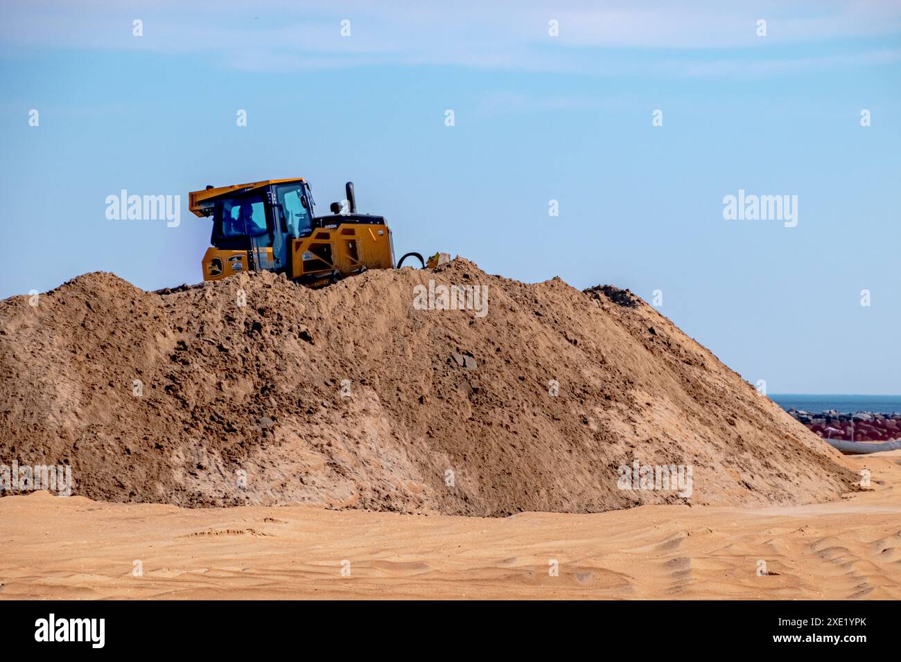 Heavy excavator working on the sand beach restoration Stock Photo - Alamy