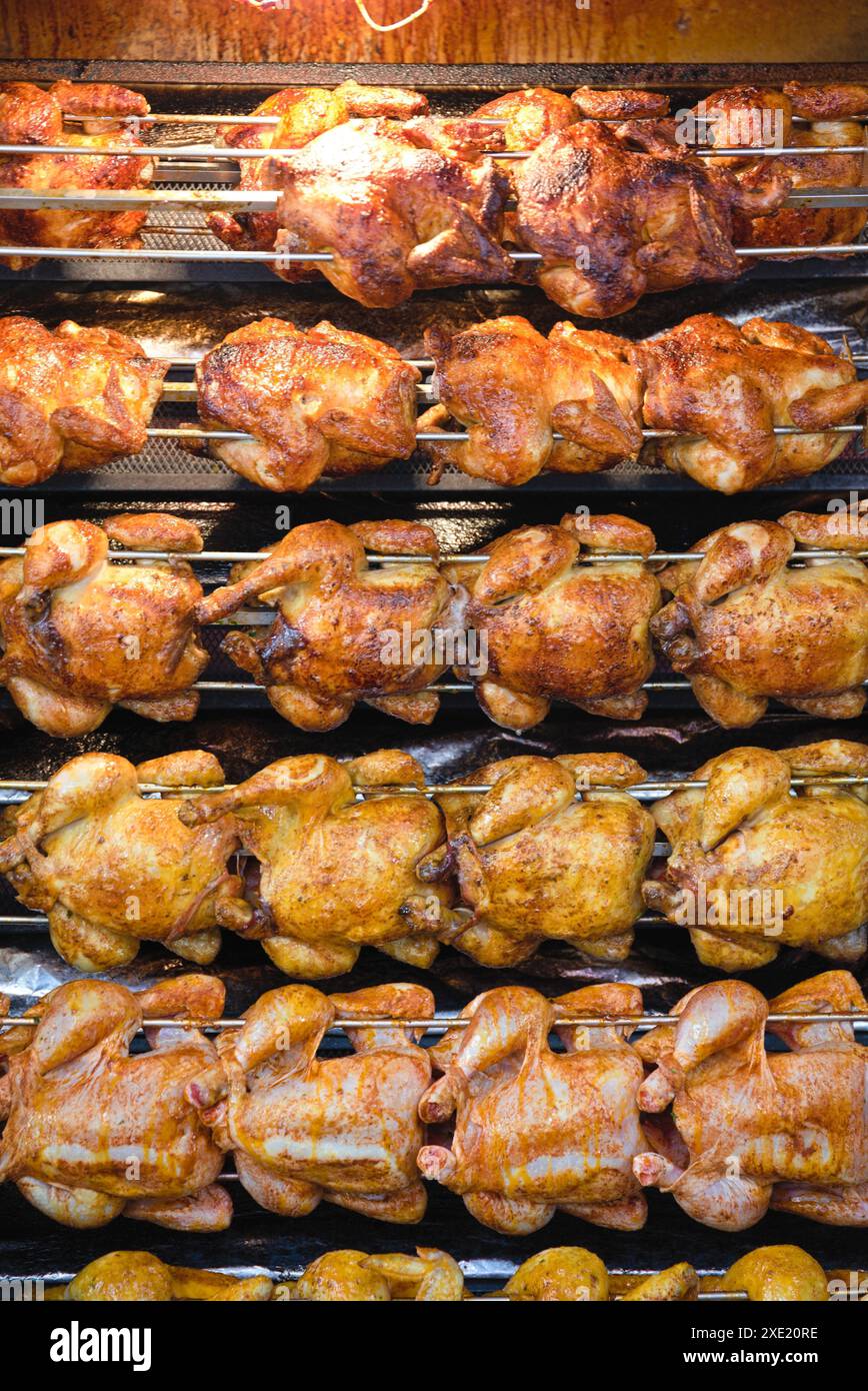 Chicken are grilled on the spit - grilled chicken Stock Photo - Alamy
