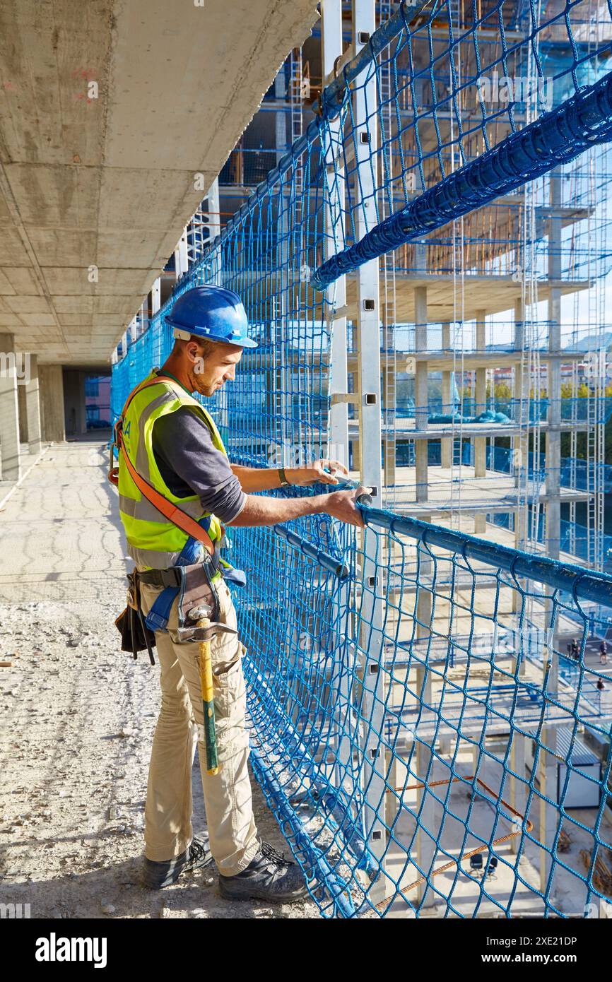 Worker placing Security System Work RESA. Protection in building work ...