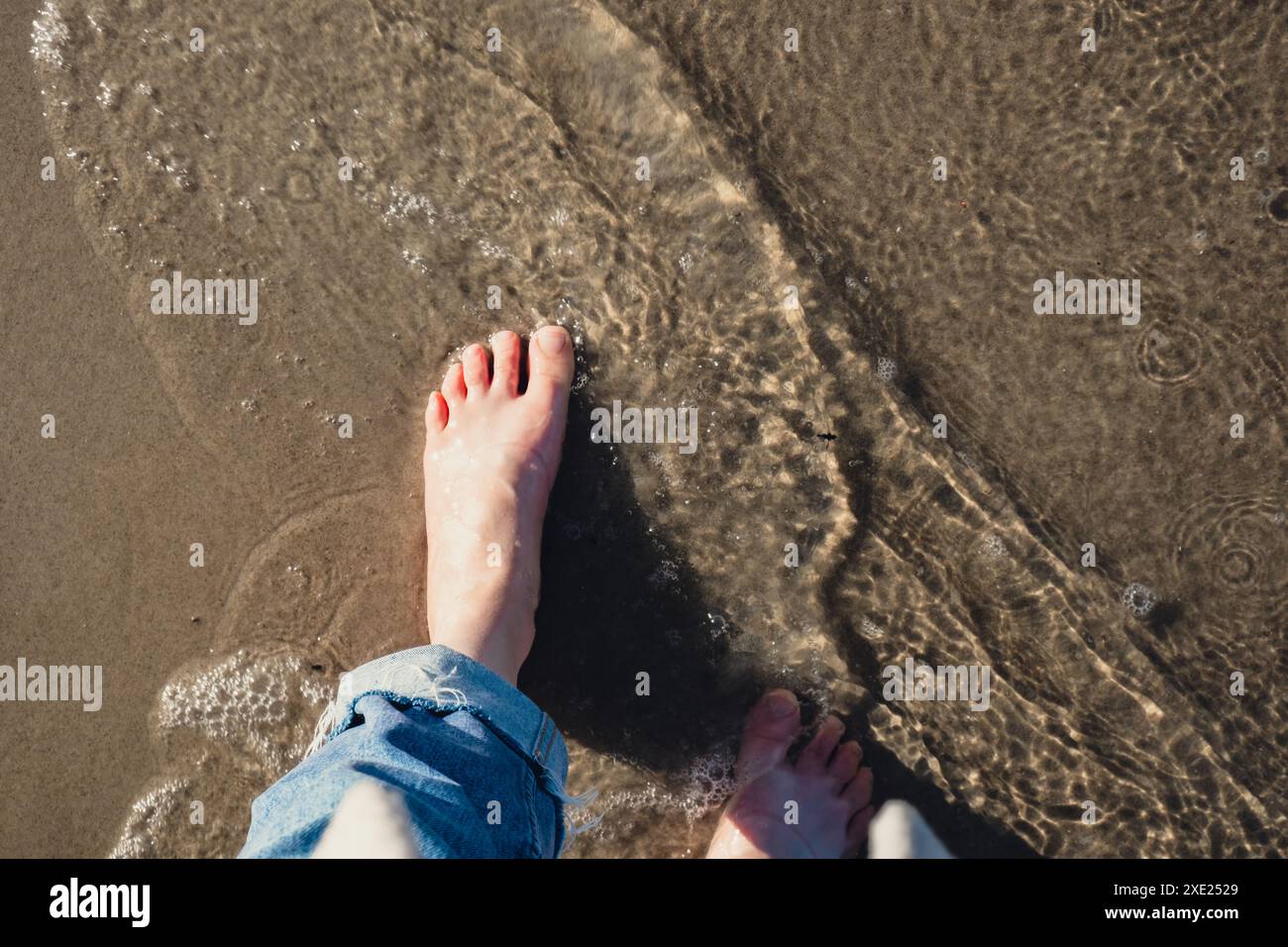 Female legs walking in sandy beach sea or ocean water surface ...