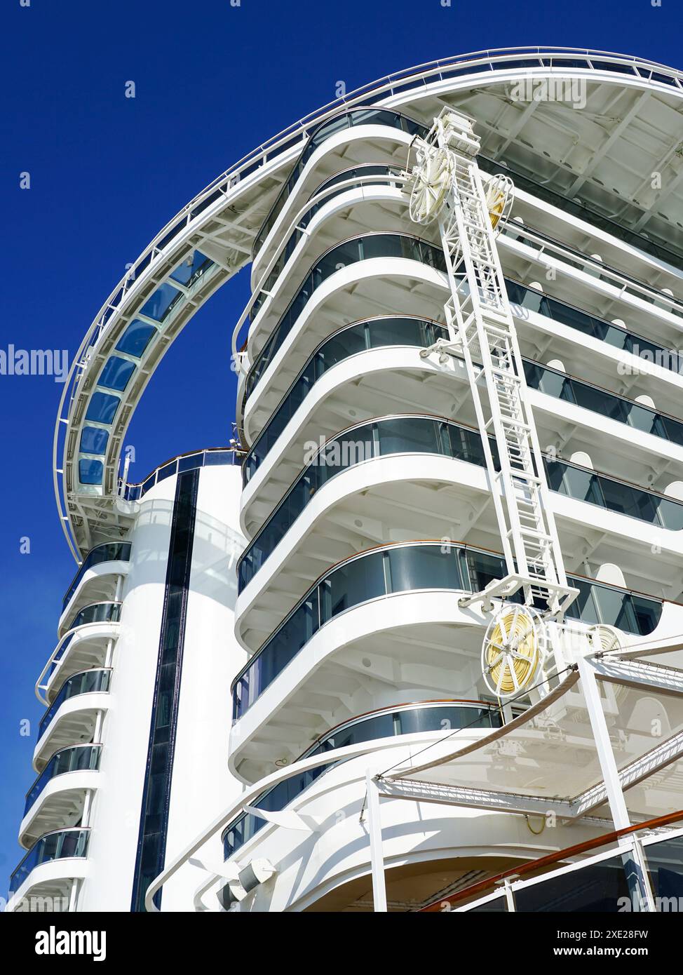 High back of a large cruise ship with balconies on a blue sky ...