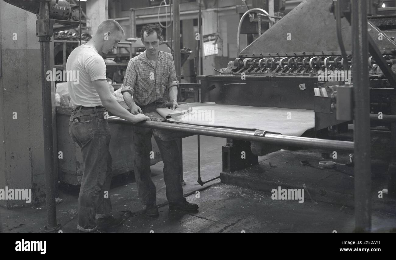 1950s, historical, two male workers checking large sheets of paper by a ...