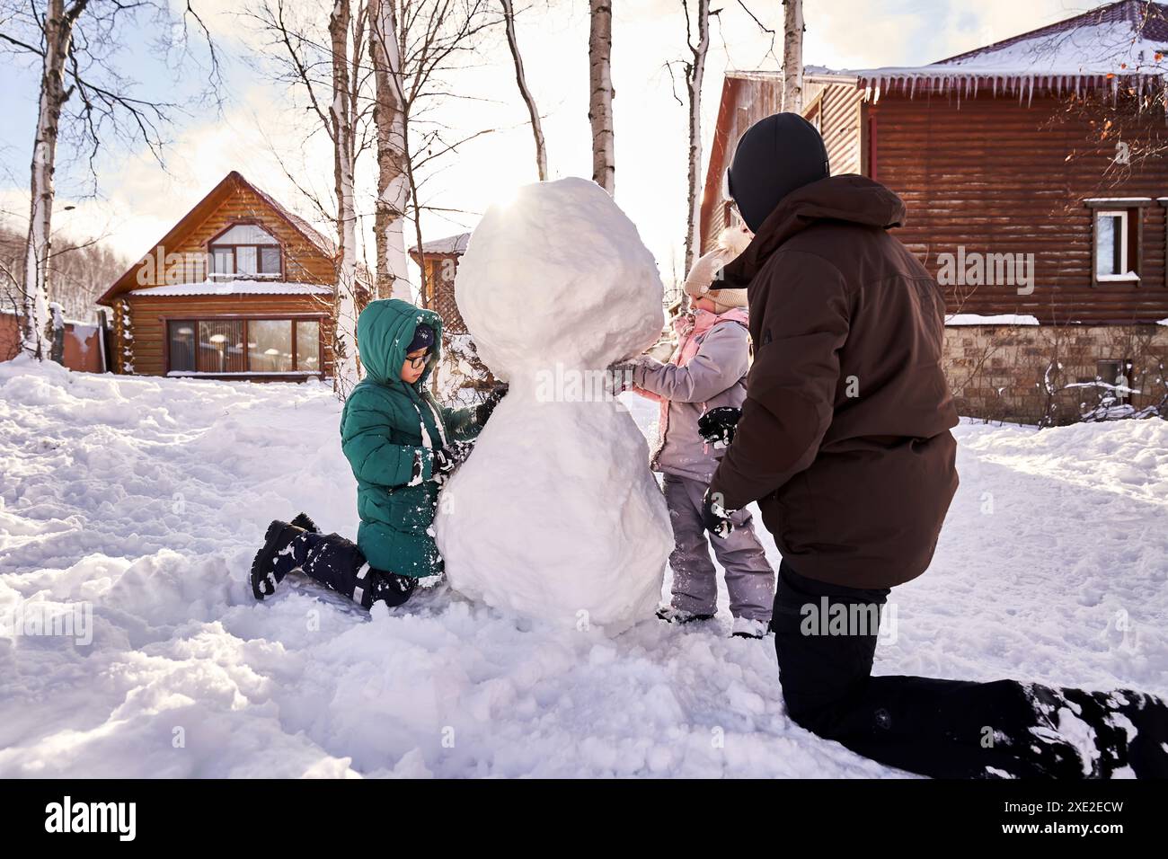 Happy family builds snowman hi-res stock photography and images - Alamy