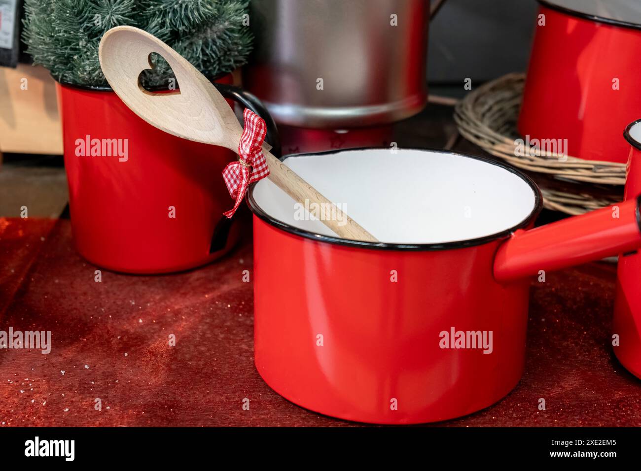 A small red pot with cooking spoon Stock Photo - Alamy
