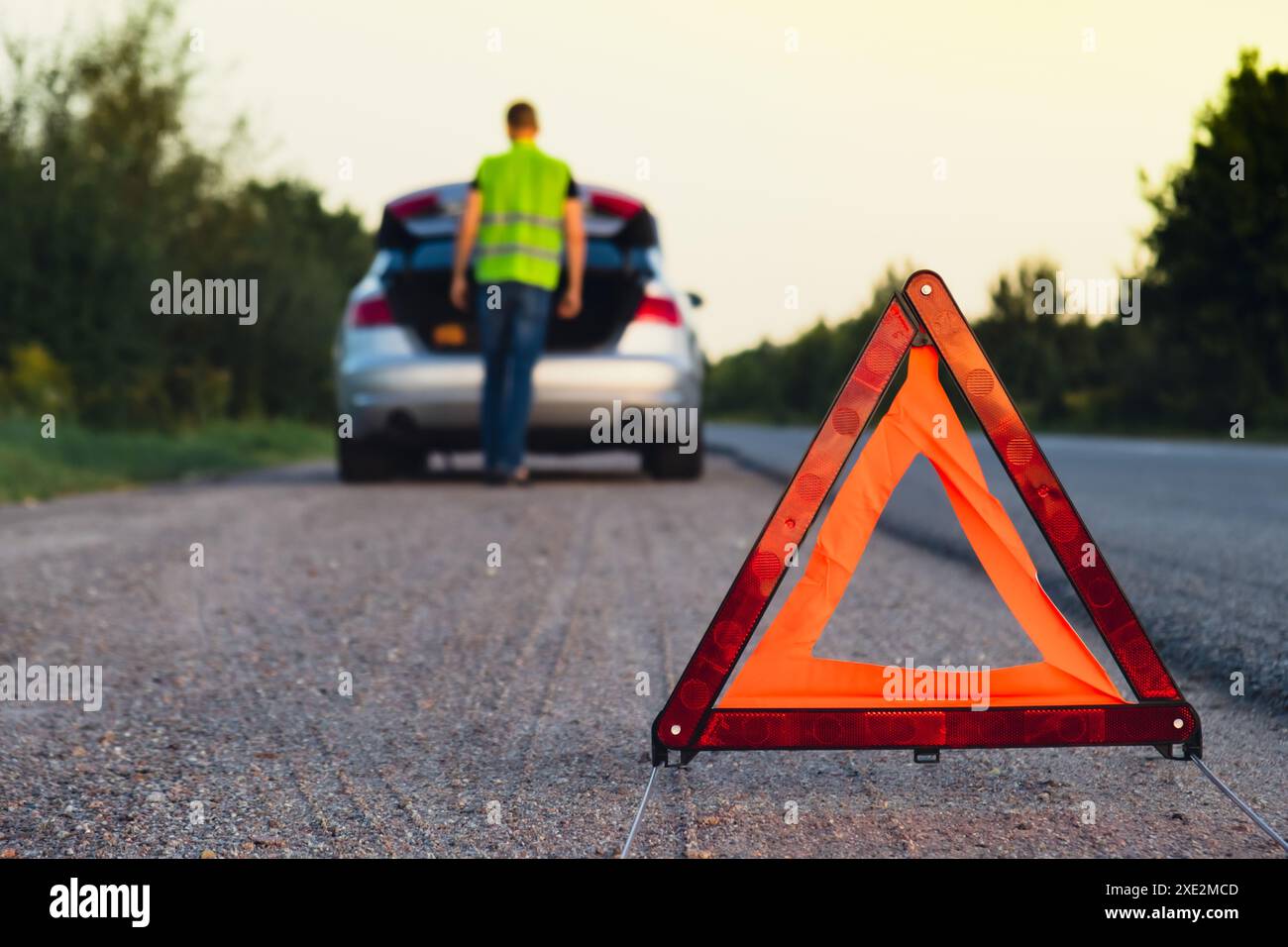 Broken silver luxury car emergency accident. Man driver installing red ...
