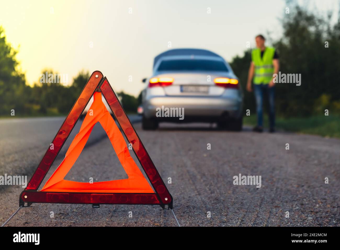 Unrecognizable sad driver in reflective vest. Male driver standing near ...