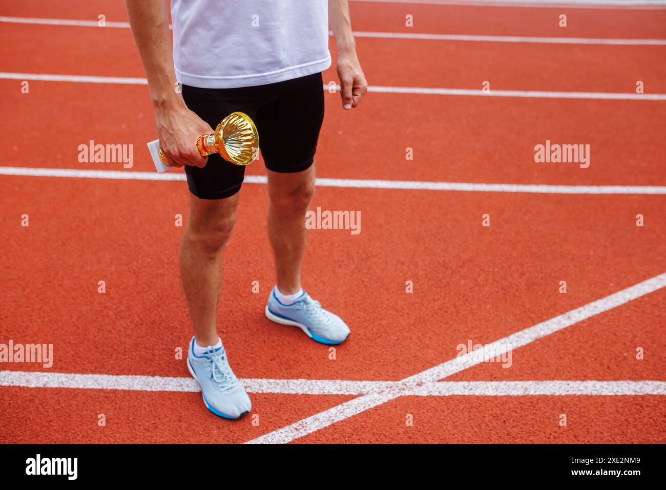 A determined athlete is in a crouched position at the starting line of ...