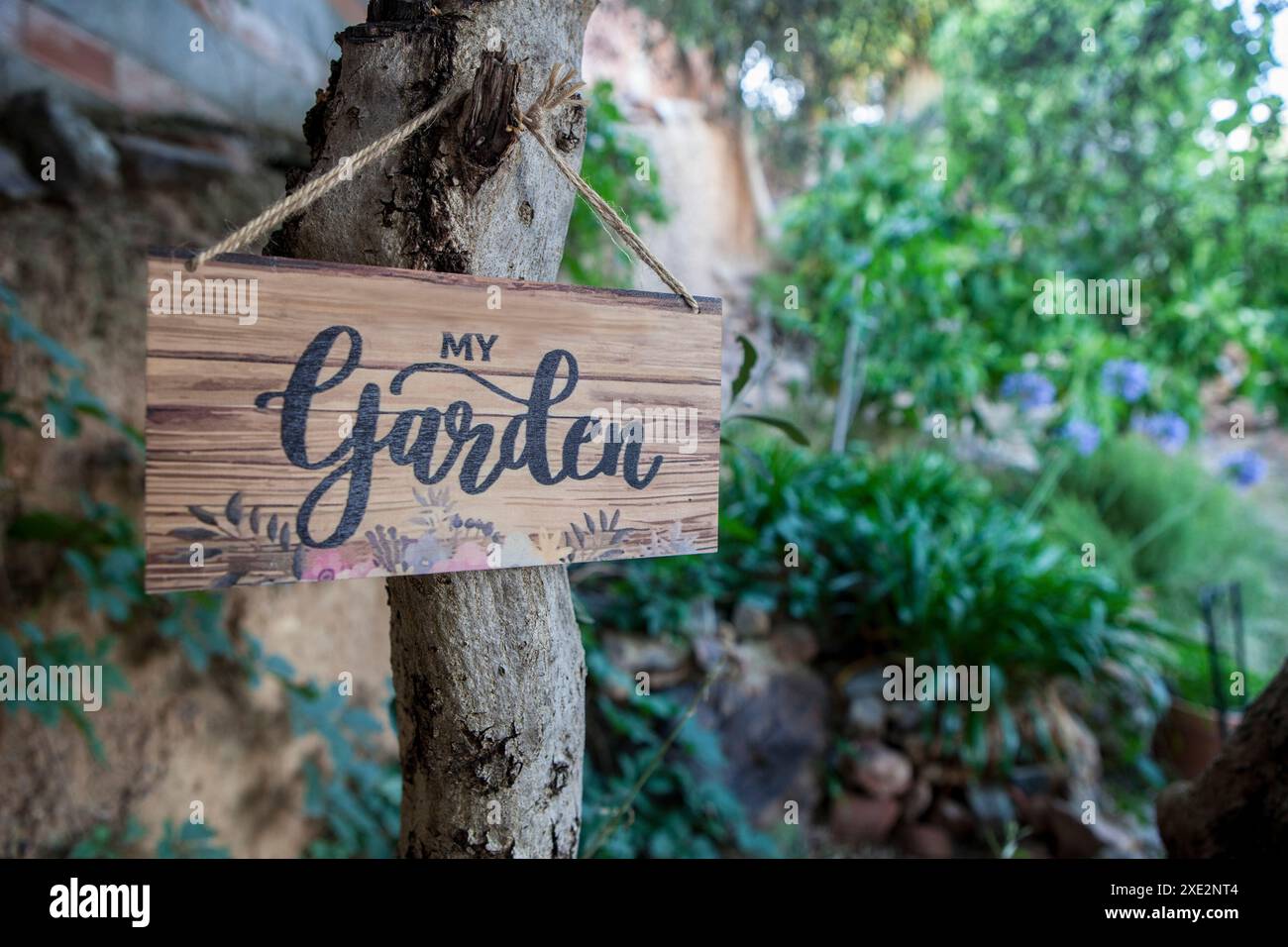 Garden welcome sign with mediterranean courtyard as background. English ...
