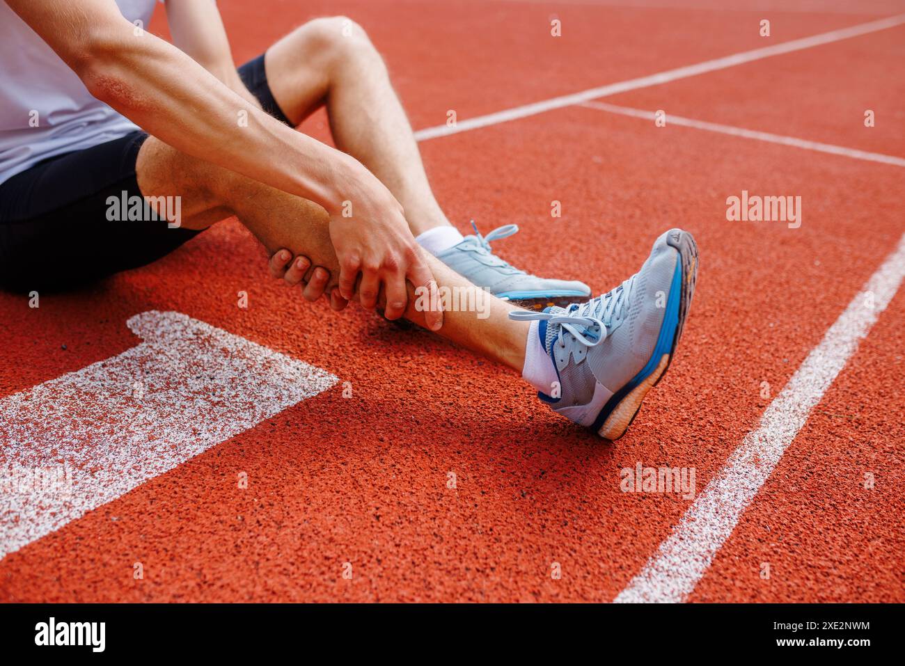Athlete holding his leg injured after running at track and field ...