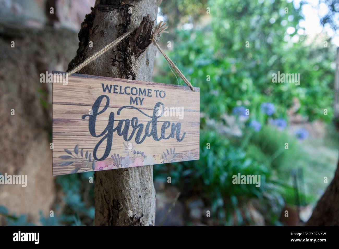 Garden welcome sign with mediterranean courtyard as background. English ...