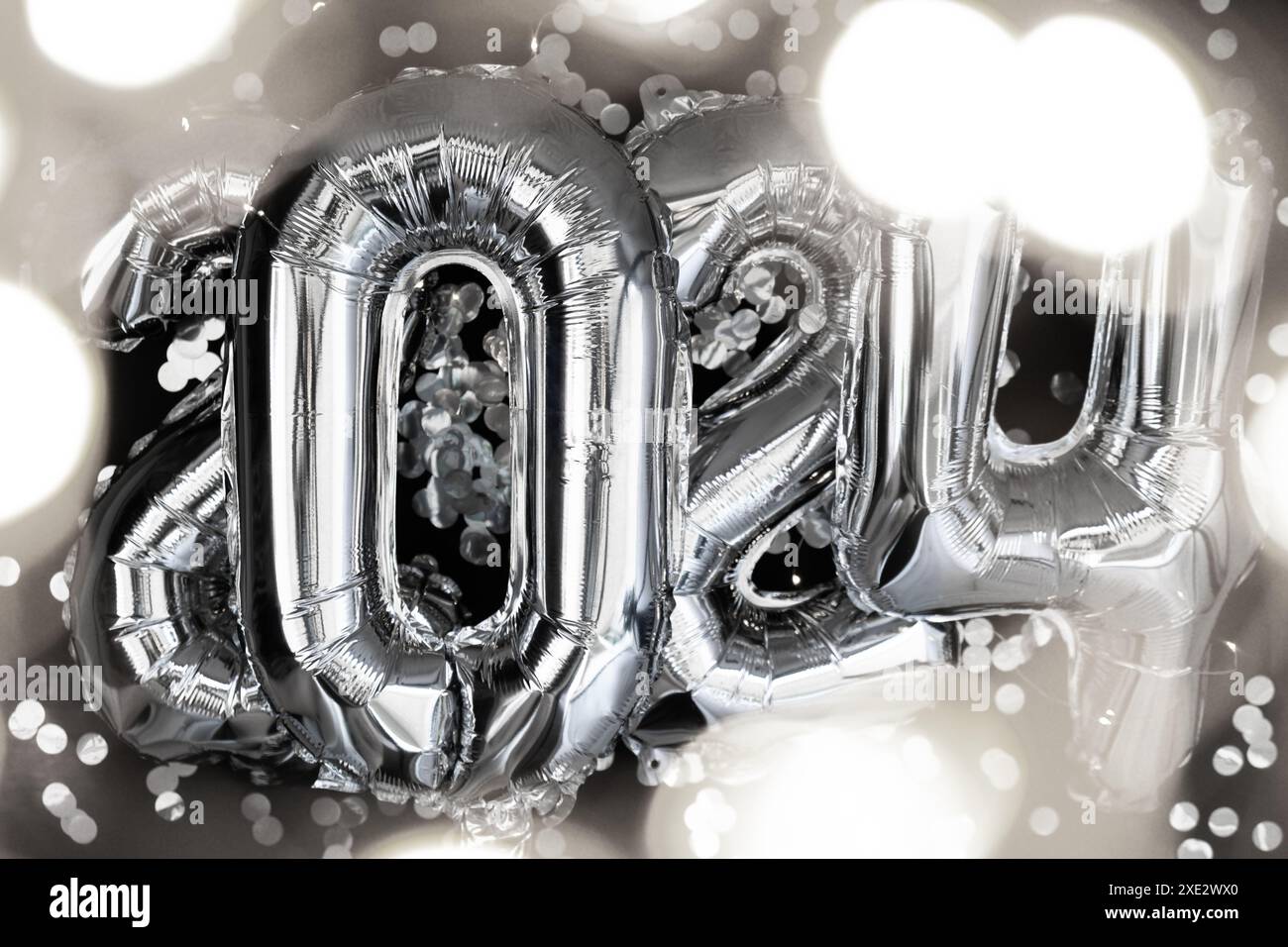Holiday bokeh garland Happy new year 2024 metallic balloons with confetti on dark black ...