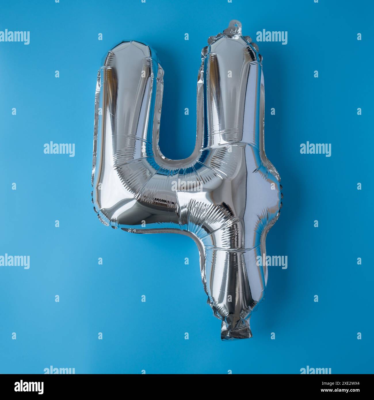 4 four metallic balloon isolated on blue background. Greeting card ...