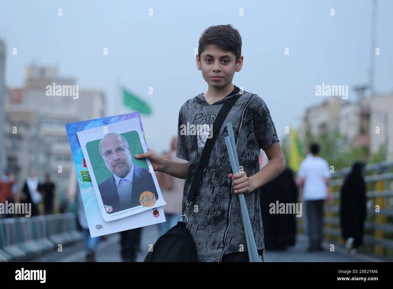 Tehran, Iran. 25th June, 2024. An Iranian boy holds a poster of ...