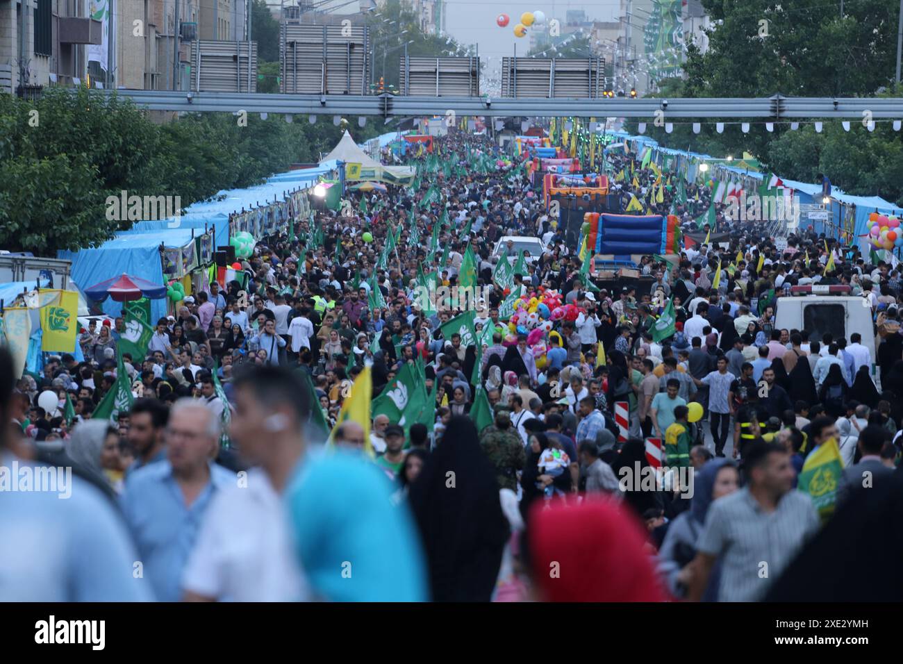 Tehran, Iran. 25th June, 2024. Iranian people walk during a ceremony to ...