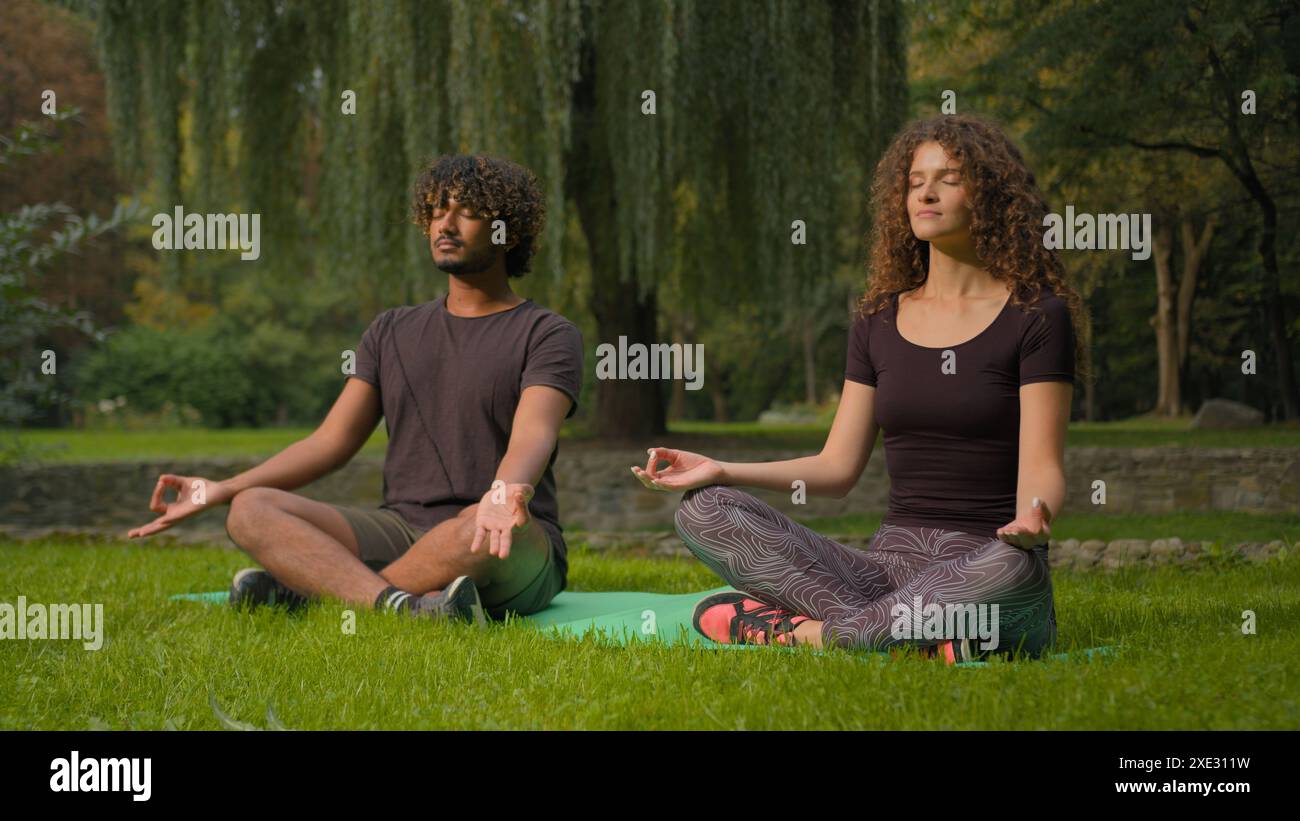 Yoga zen Caucasian woman Arabian man in morning nature peace health ...