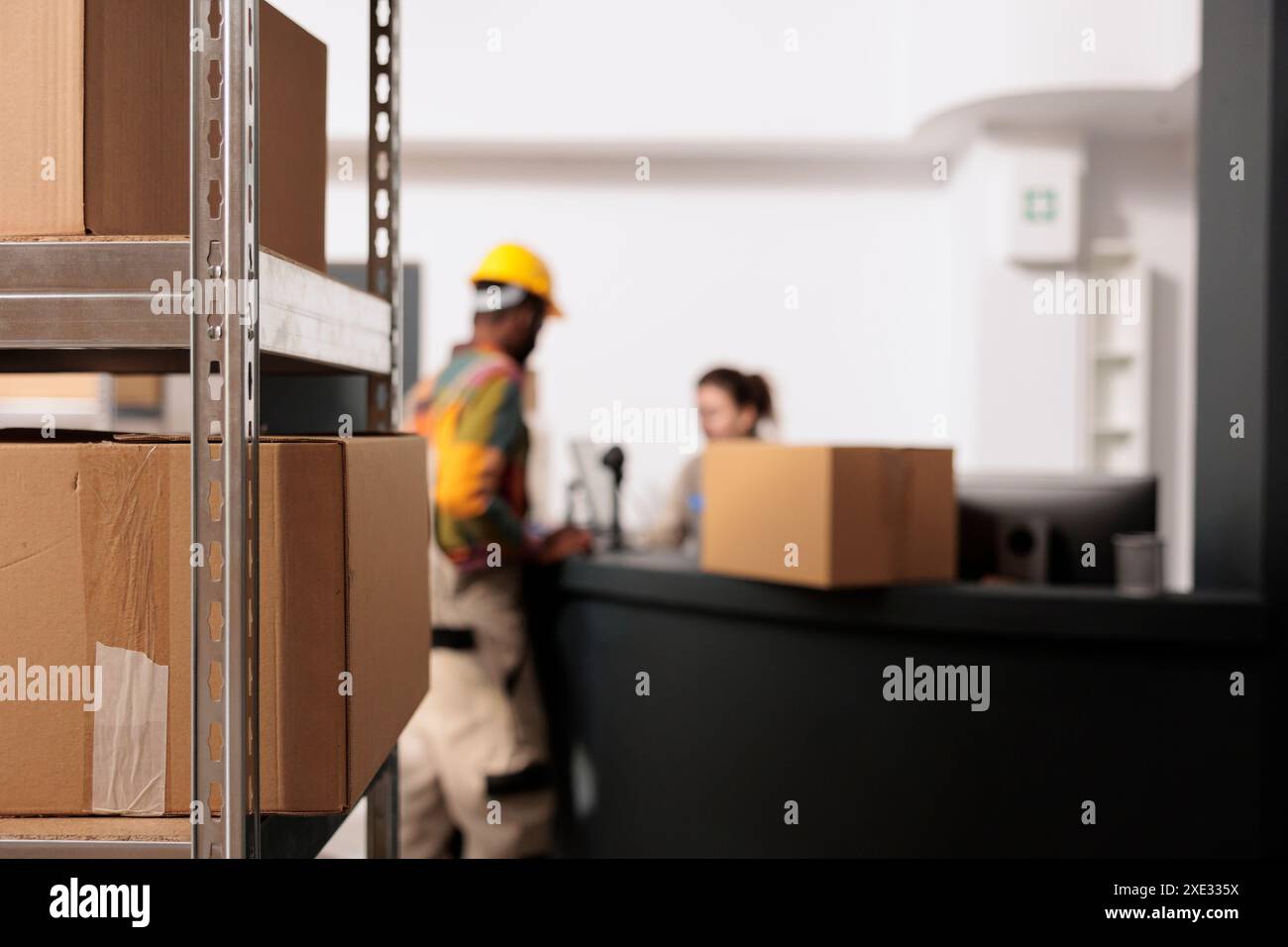 Selective focus of metallic shelves in warehouse, full with cardboard boxes ready for shipping ...