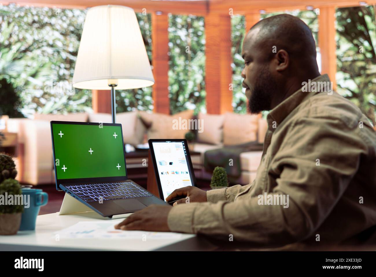 Financial adviser works with infographics next to a copy space mockup ...