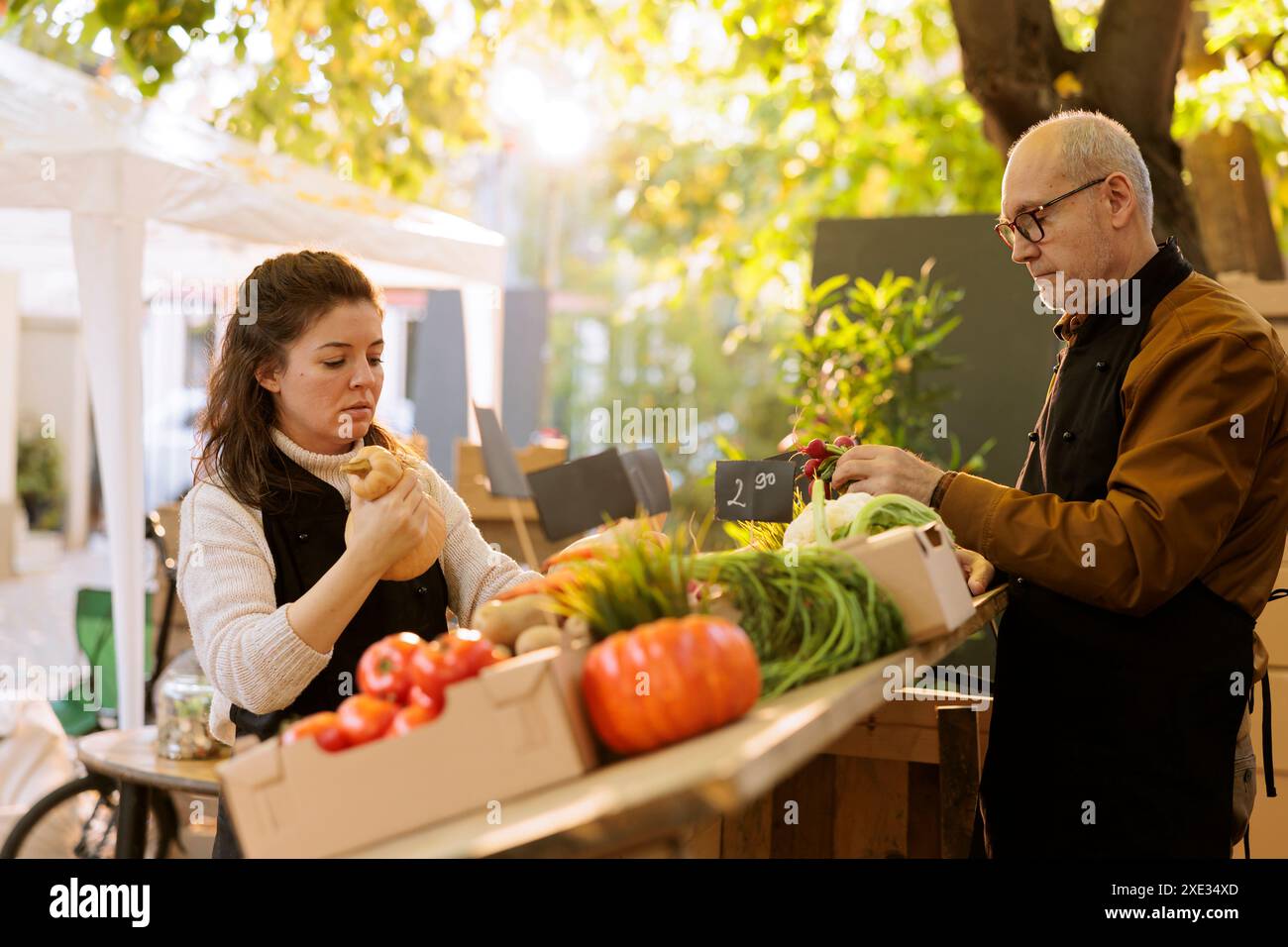 Woman selling fresh product is helping an elderly man organize ...