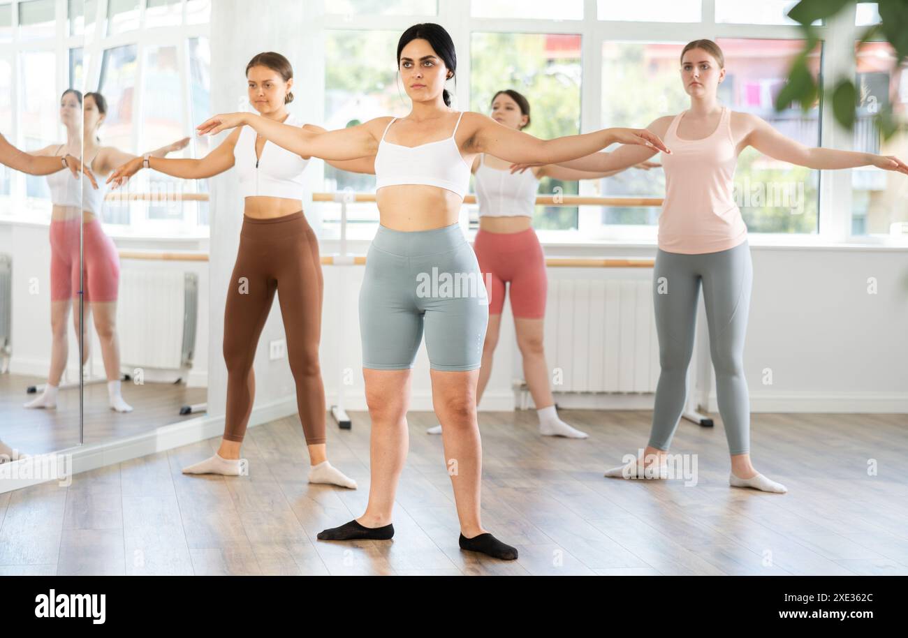Young girl mastering ballet moves at group class Stock Photo - Alamy