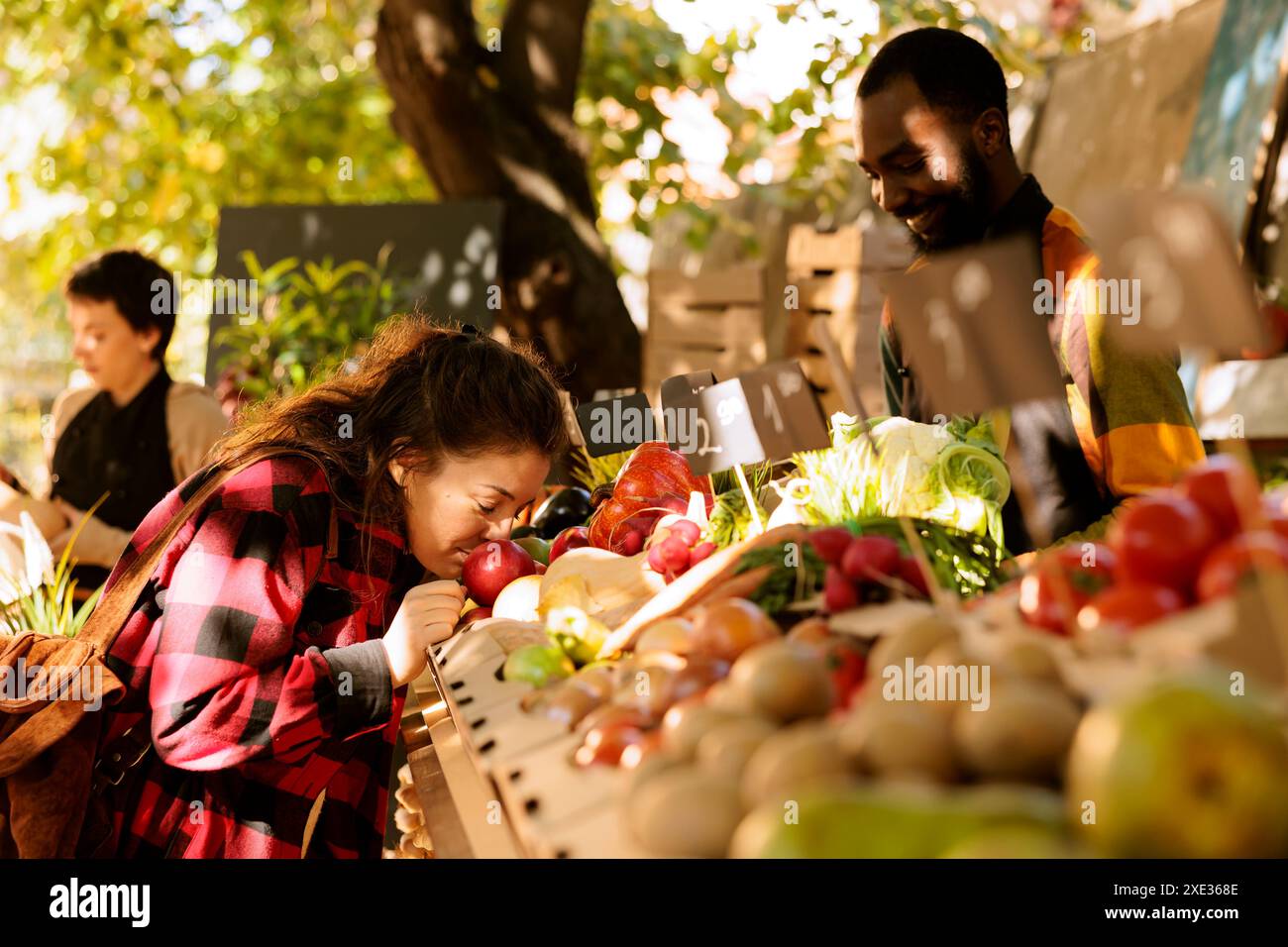 Female consumer standing close to market stall, selecting locally grown ...