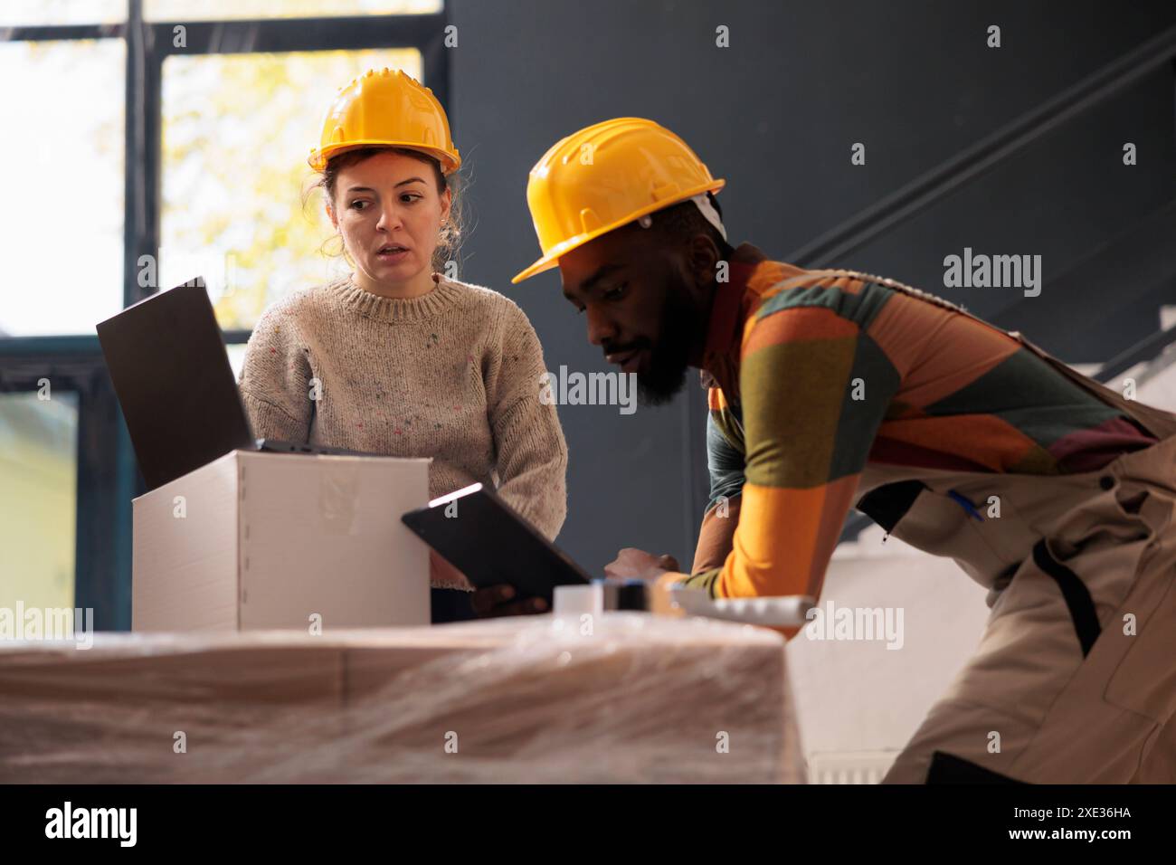 Diverse warehouse coworkers preparing cu clients orders using cardboard ...