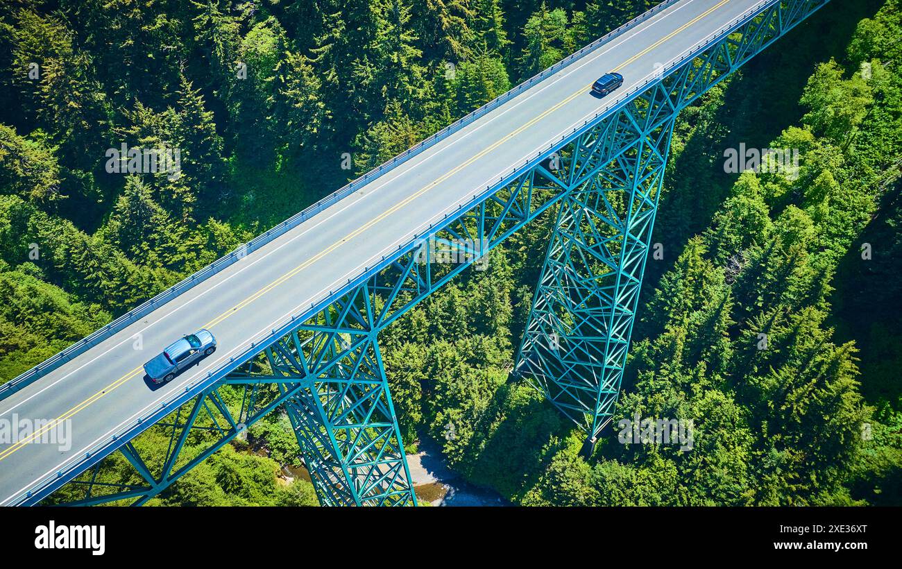 Aerial View of Blue Steel Bridge Over Lush Forest with Car in Motion ...