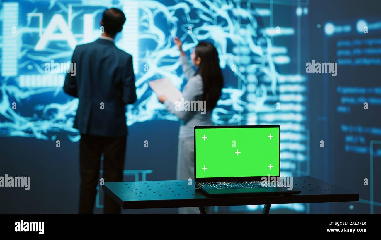 Teamworking AI technicians using green screen laptop for business data ...