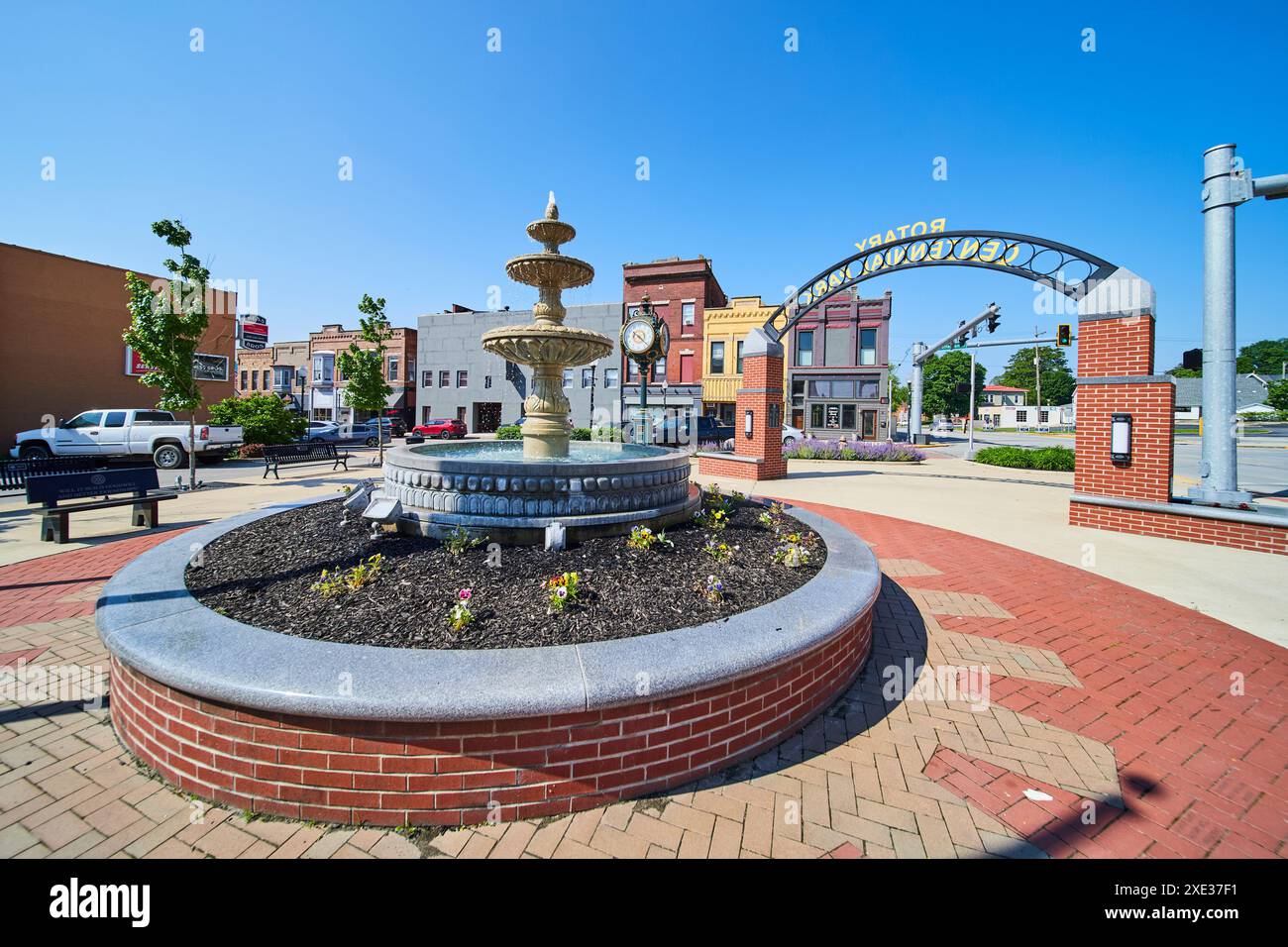 Rotary Centennial Park Fountain and Archway with Colorful Storefronts ...