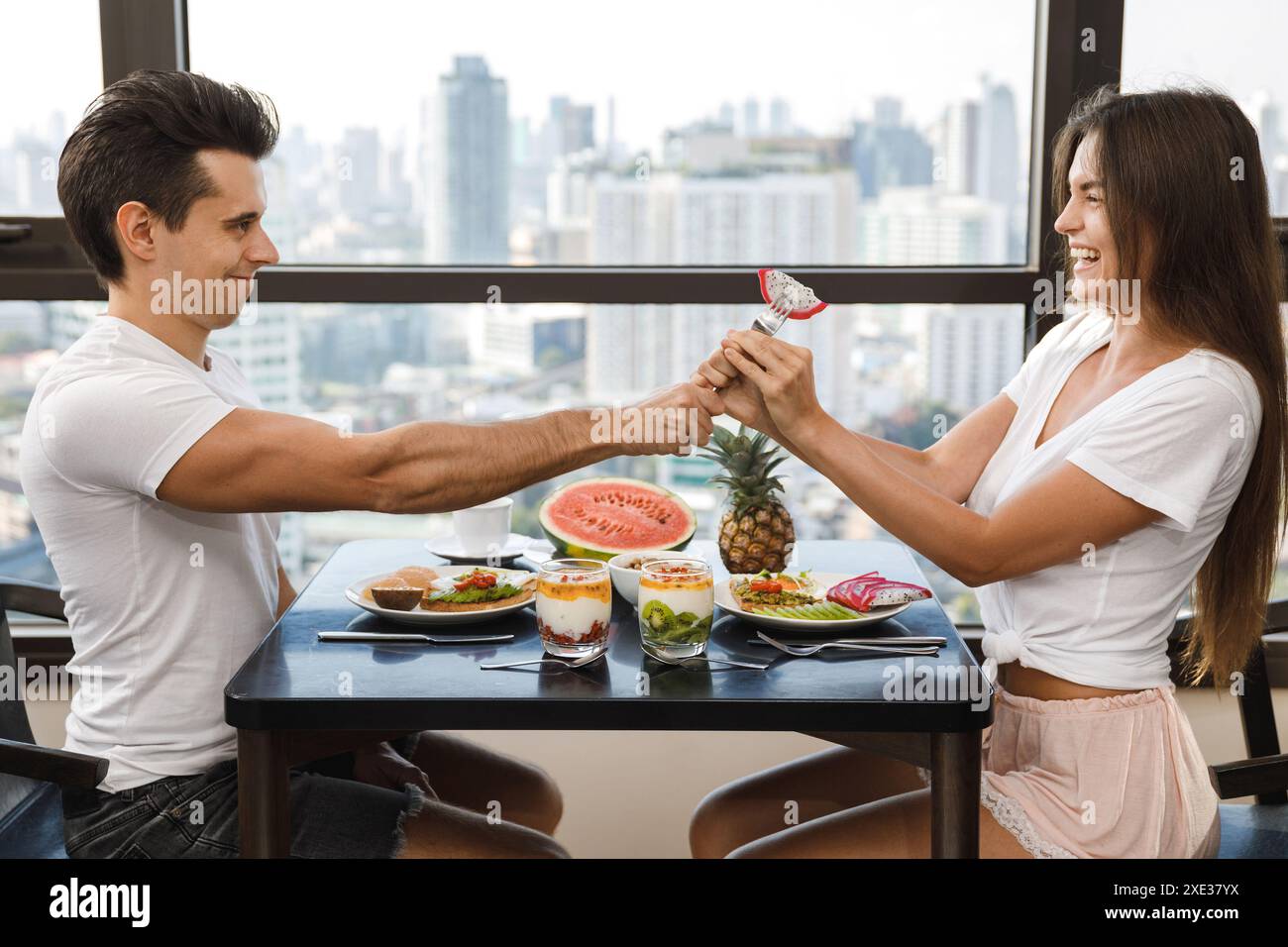 Young cheerful couple playfully fights with cutlery during the ...