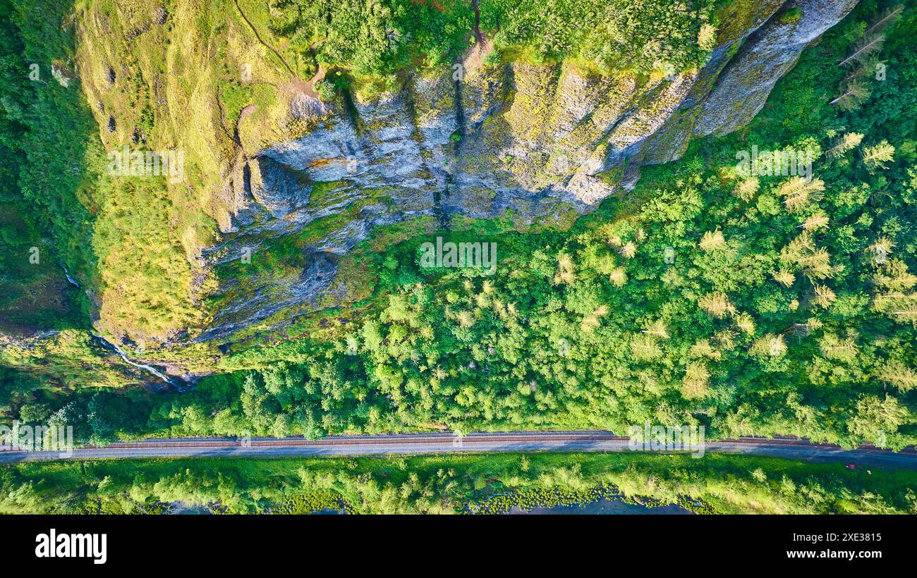 Aerial View of Lush Forest and Rocky Cliff with Winding Road Stock ...