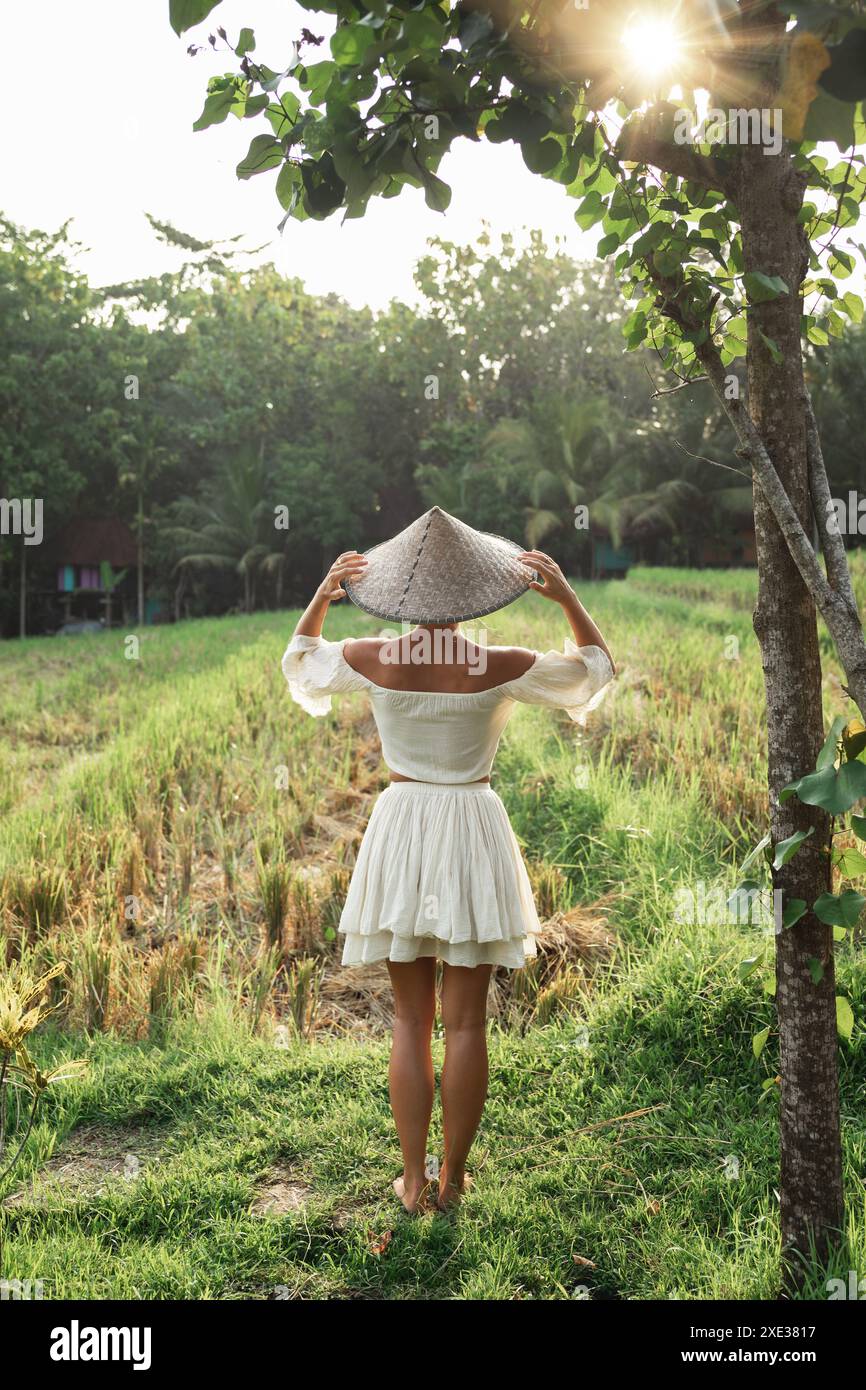 Woman wearing natural clothes and Asian conical hat in the rice field ...