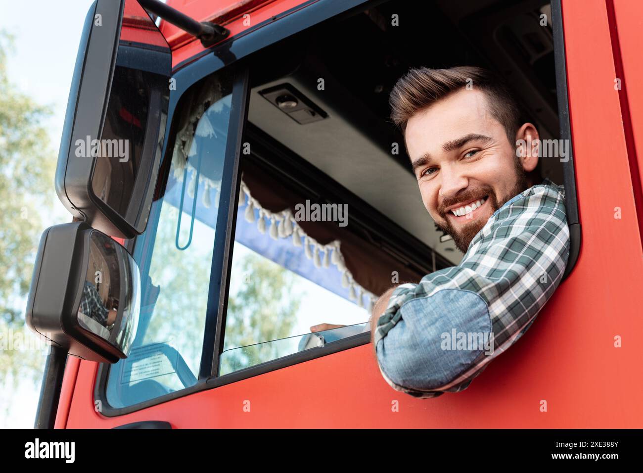 Happy male truck driver inside his red cargo truck Stock Photo - Alamy