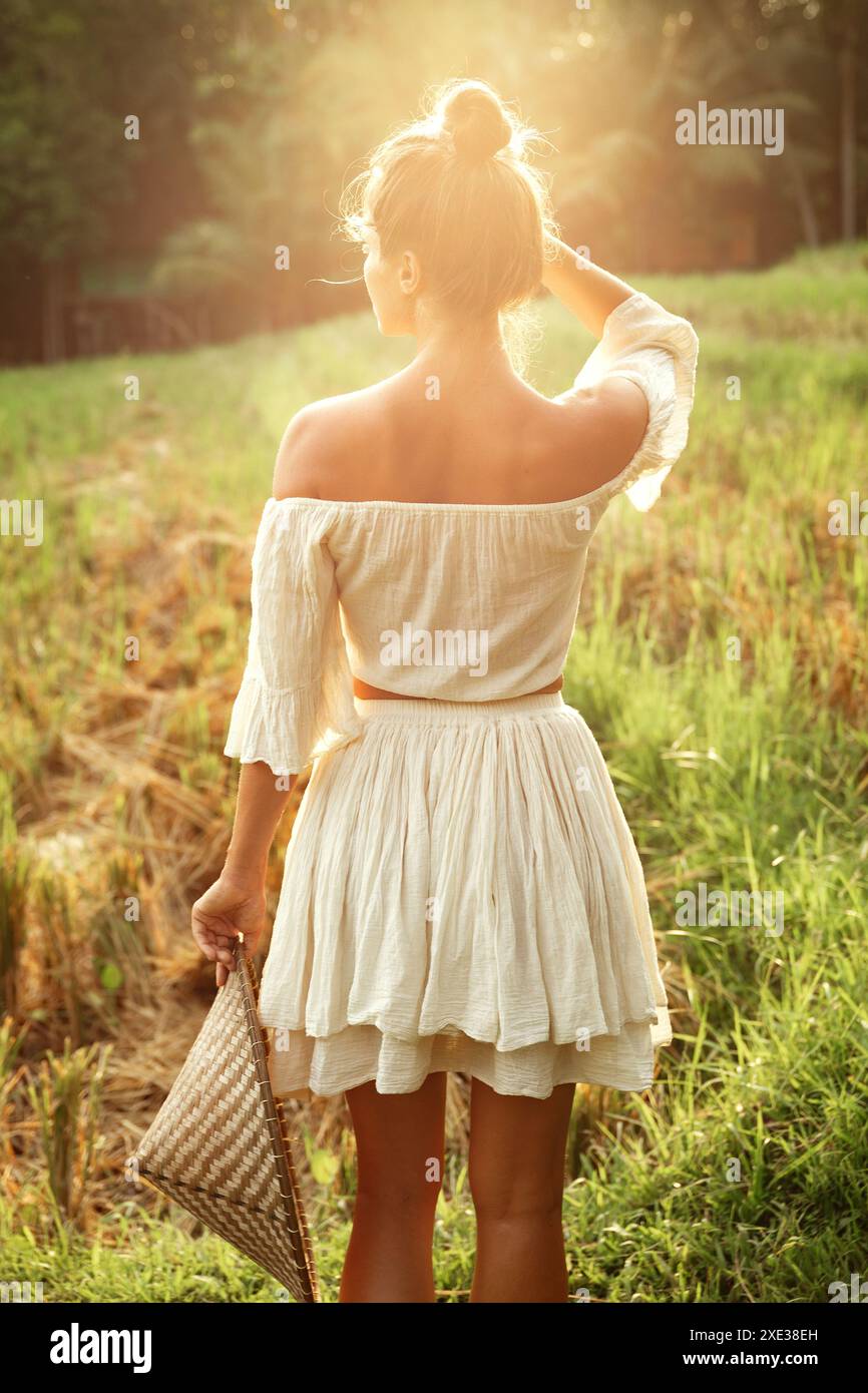 Woman wearing natural clothes holding Asian conical hat in the rice ...