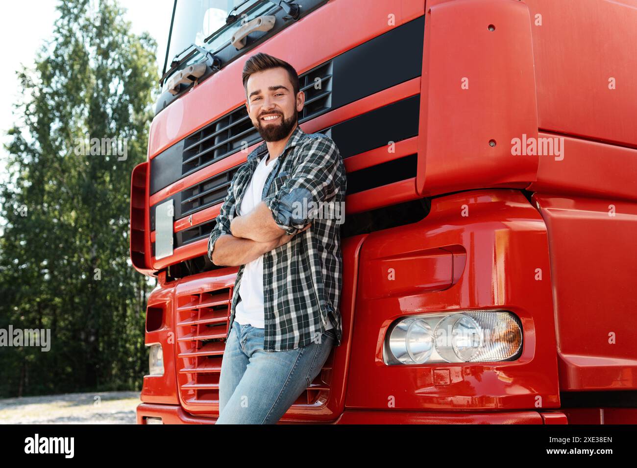 Young smiling male truck driver beside his red cargo truck Stock Photo ...