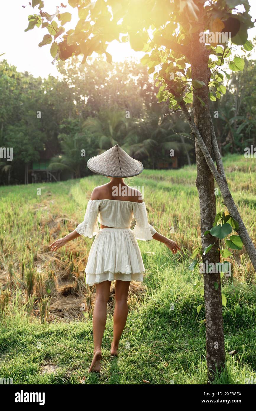 Woman wearing natural clothes and Asian conical hat in the rice field ...