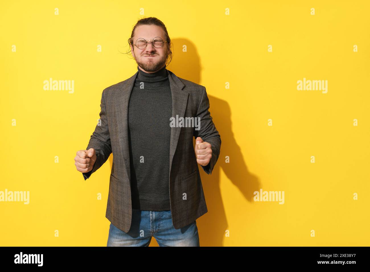 Man making silly face against yellow background Stock Photo - Alamy