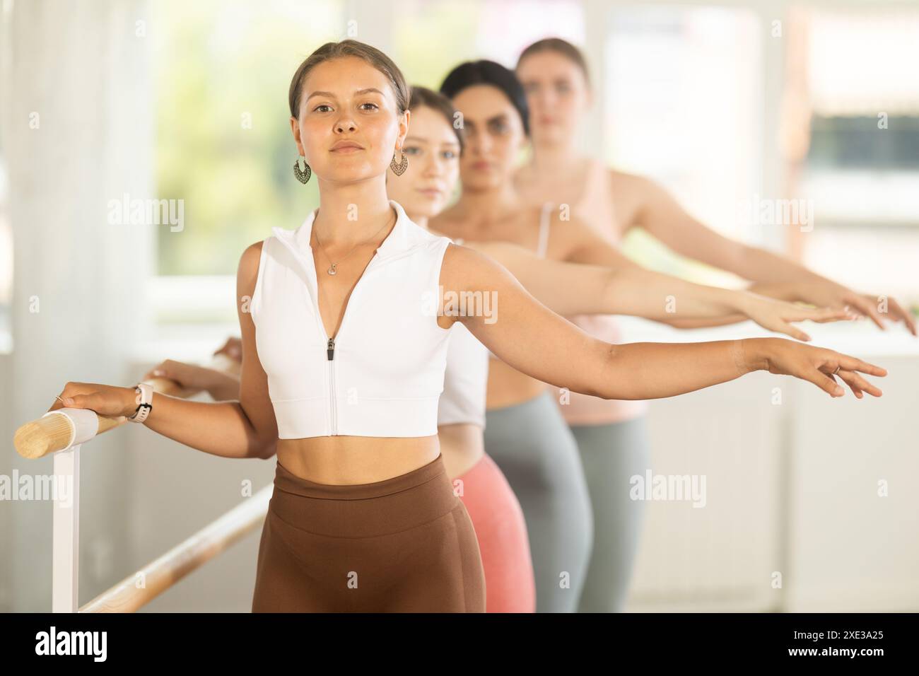 Young girl practicing second arm position holding by ballet barre Stock ...