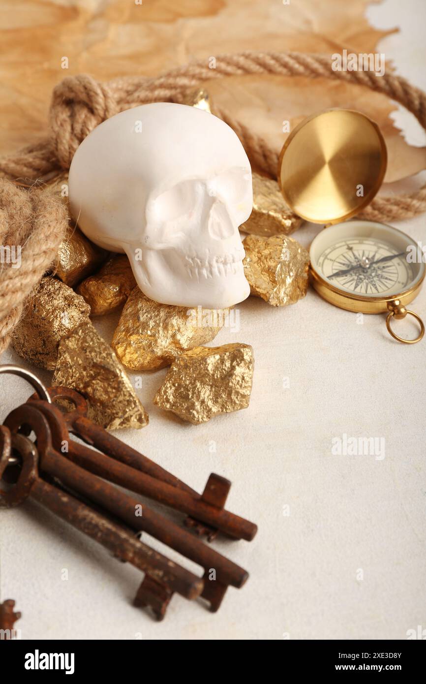 Human scull with travel equipment, keys and golden nuggets on white ...