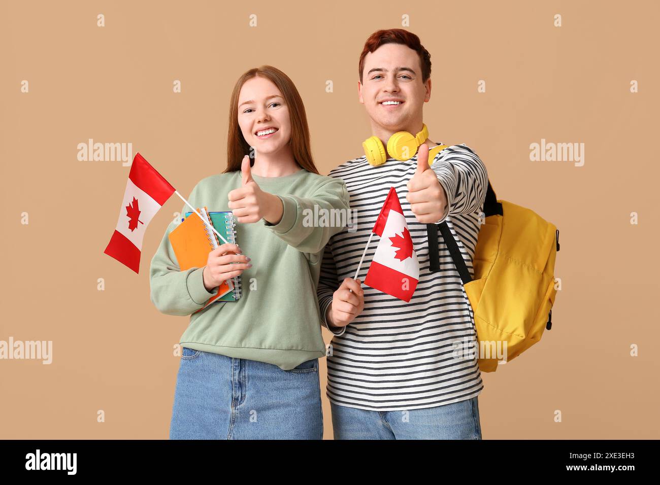 Students with flags of Canada, notebooks and backpack showing thumb-up ...