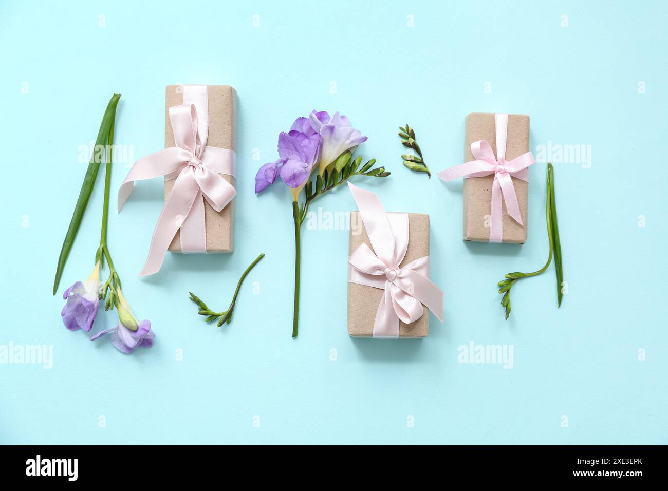 Beauty wrapped gift boxes decorated with natural flowers on cyan ...