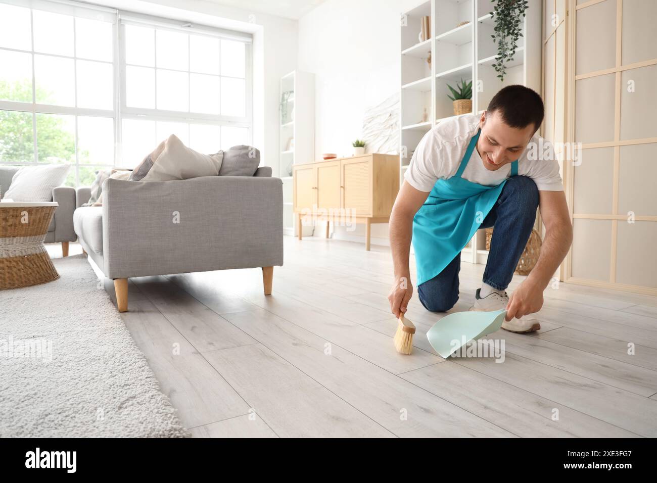 Male janitor sweeping floor in room Stock Photo - Alamy