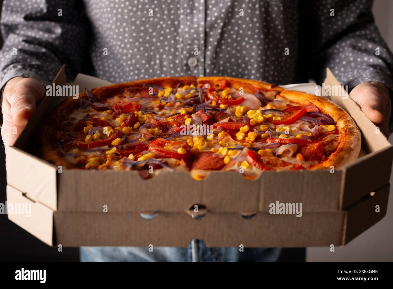 Caucasian male hands hold large open carton box with pepperoni pizza ...