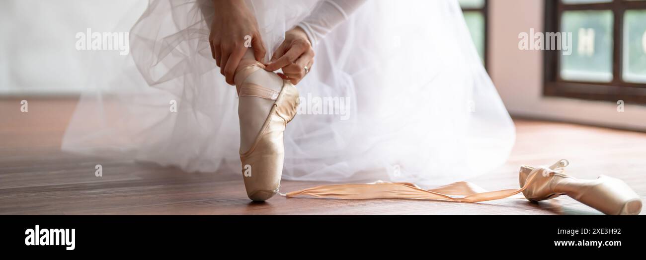 Ballerina in ballet shoes. Asian girlÂ tying ribbons of toe shoes ...