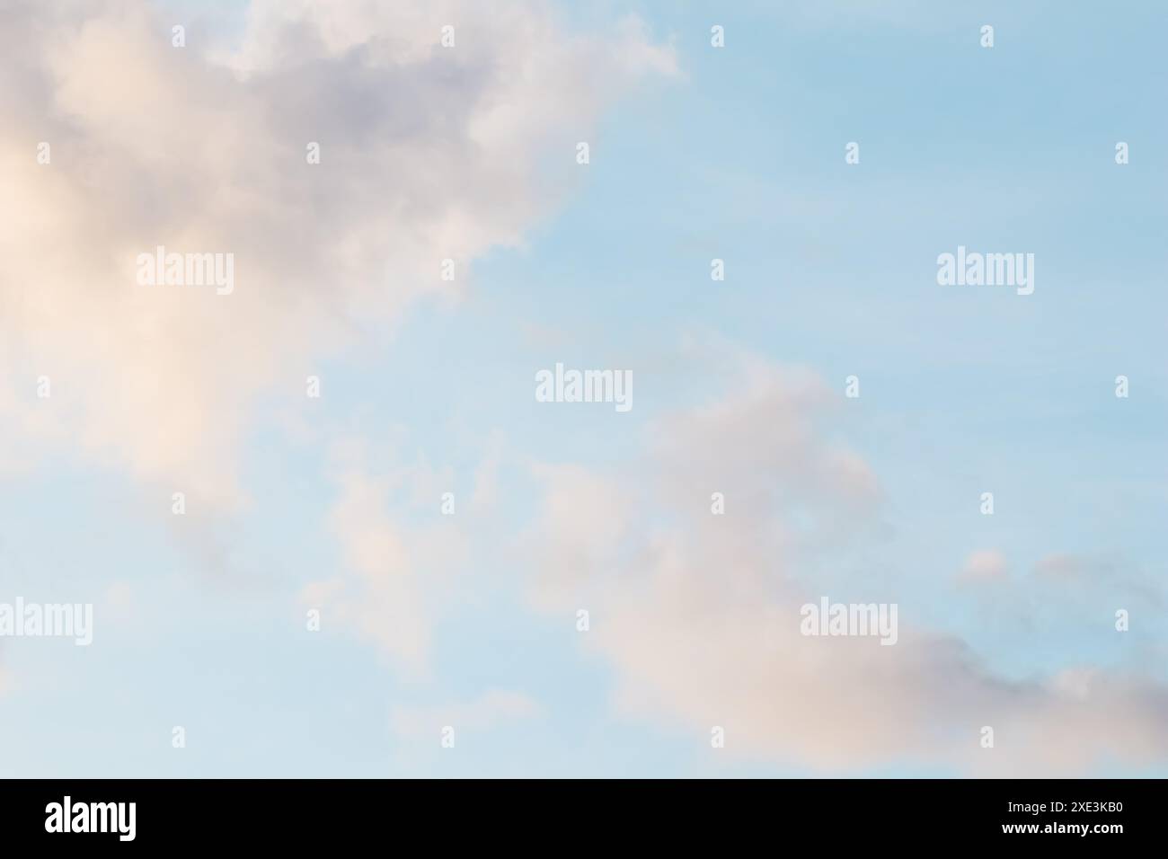 Blue sky background with pale pink clouds at sunset Stock Photo - Alamy