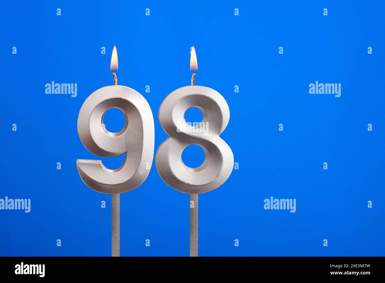 Birthday number 98 - Candle lit on blue background Stock Photo - Alamy