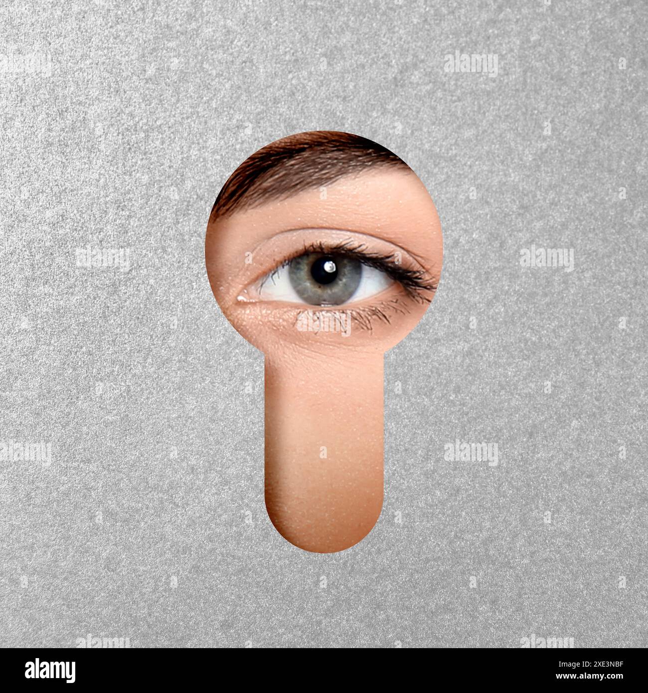 Woman looking through keyhole in grey surface Stock Photo - Alamy